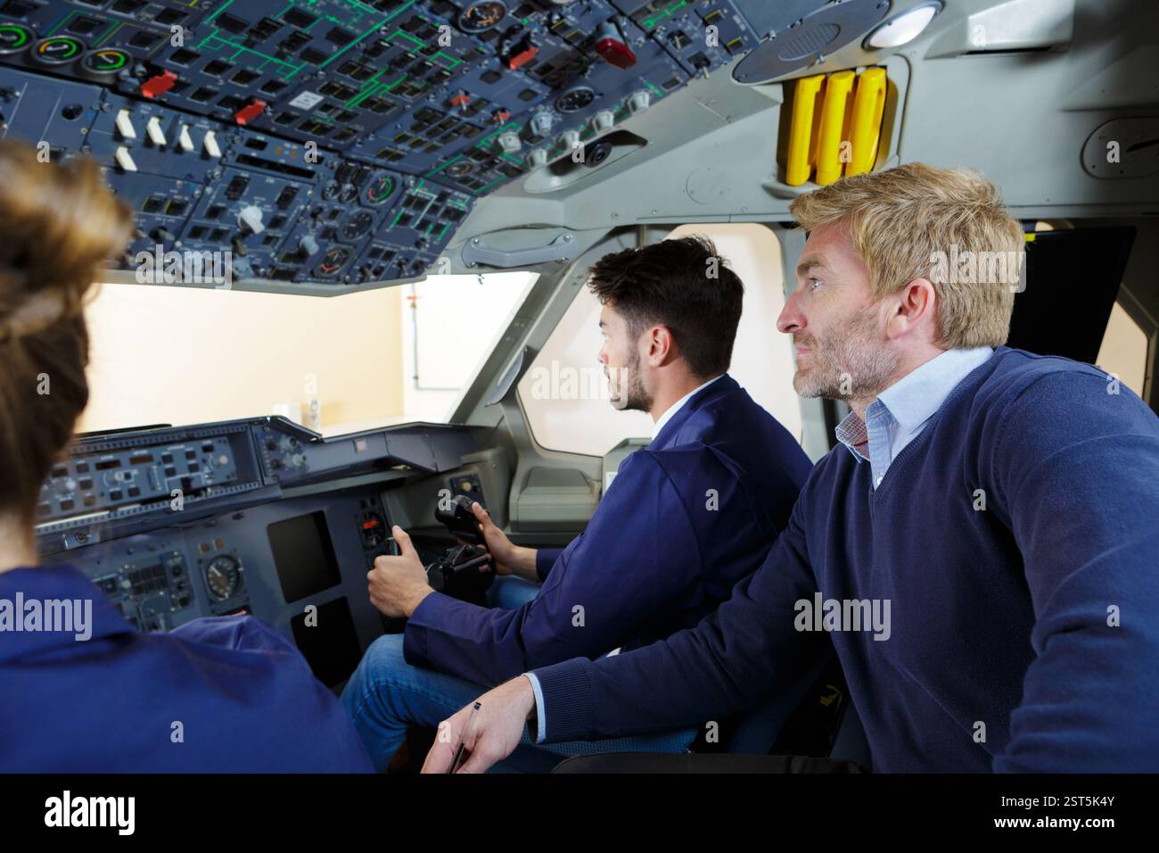 two pilots dressed in uniform flying jet airliner Stock Photo - Alamy