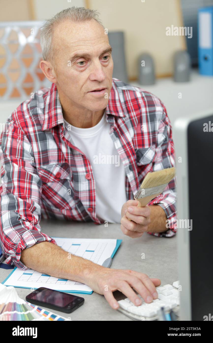 checking reference number in his computer Stock Photo - Alamy