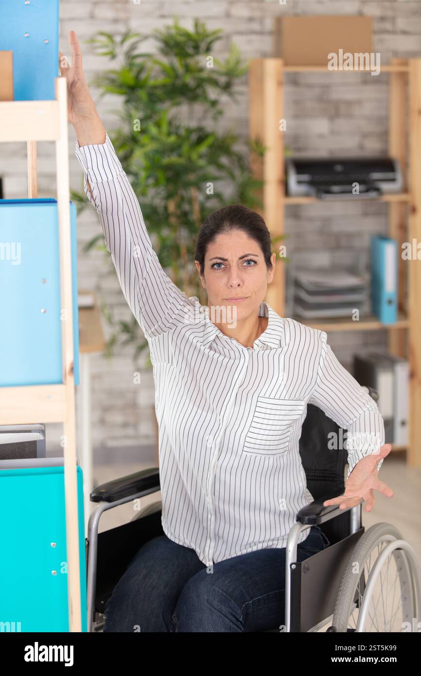 disabled office worker in wheelchair trying to reach files Stock Photo ...