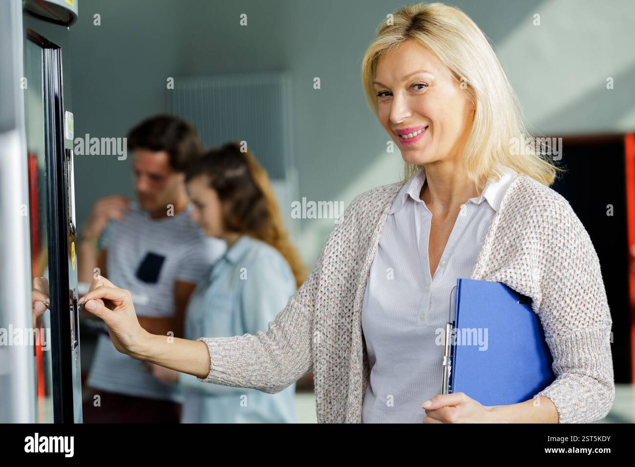 woman pushing button on vending machine Stock Photo - Alamy