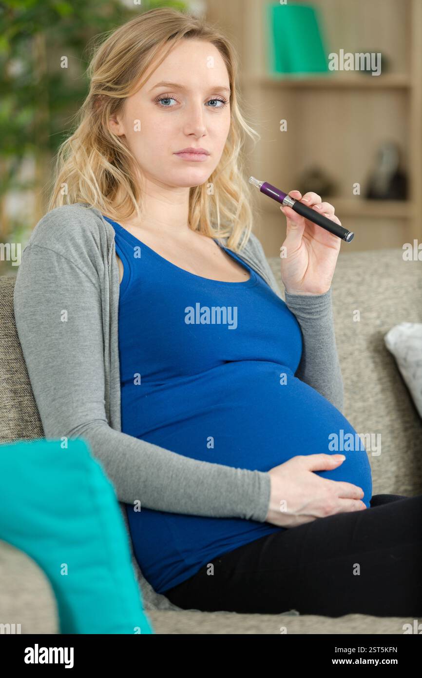 charming ginger girl with baby in belly with electronic cigarette Stock ...