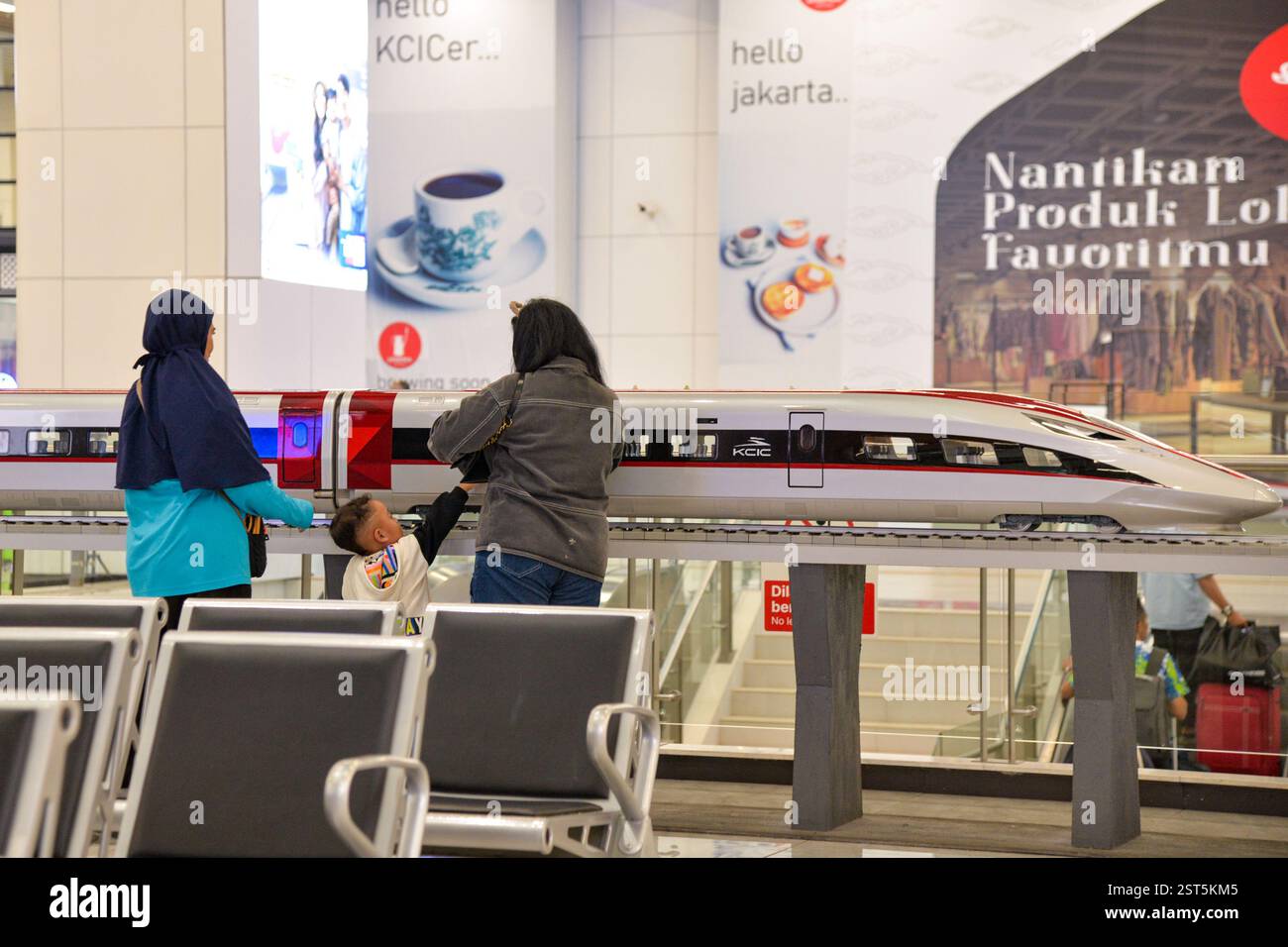 Jakarta, Indonesia. 17th Feb, 2025. Passengers with a child watch a model of a high-speed ...
