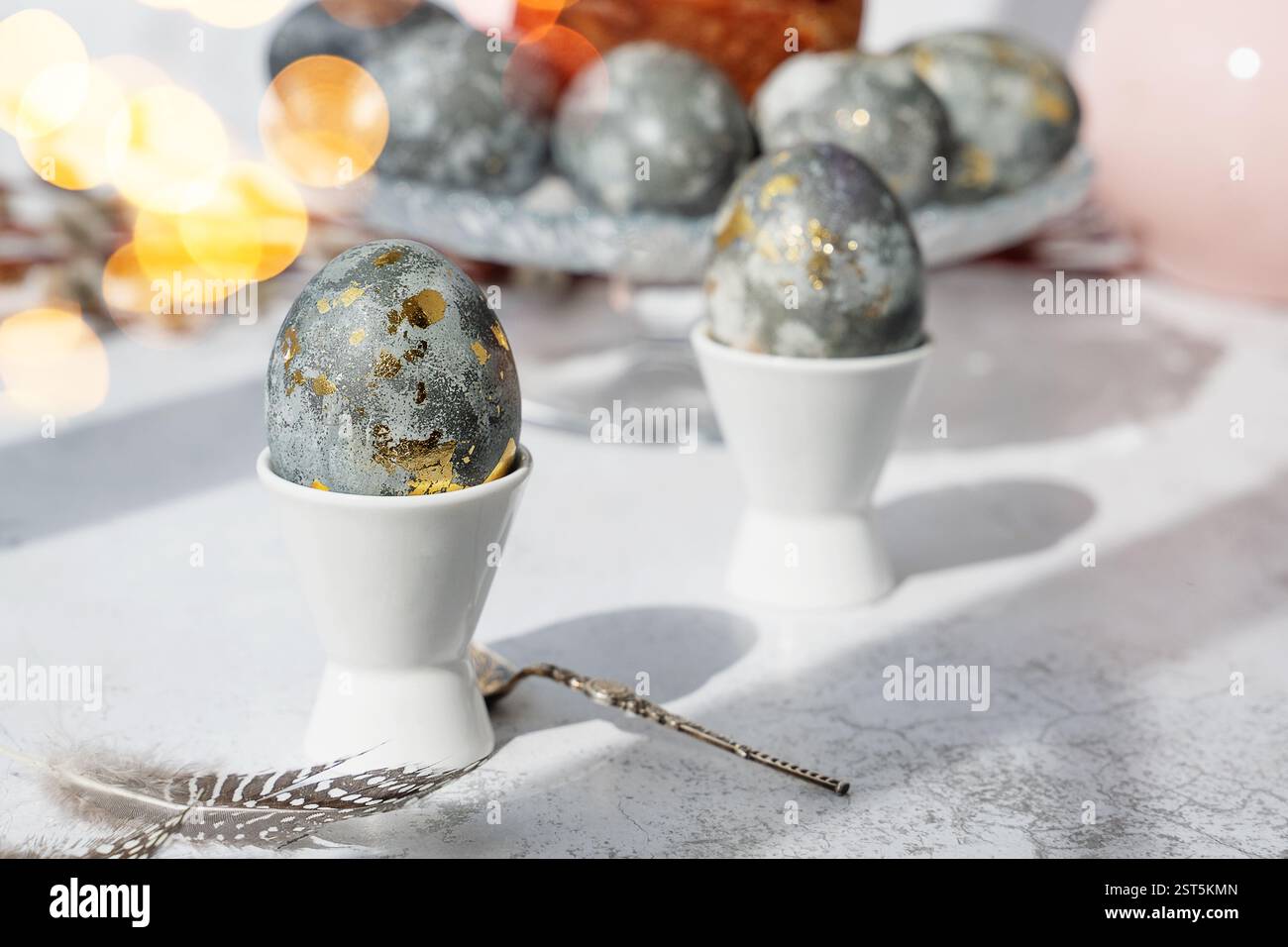A vibrant table displays beautifully crafted eggs with metallic accents ...