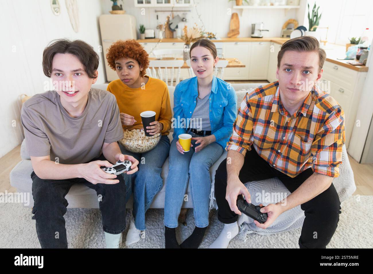 Home party. Cheerful group of friends playing video games at home ...