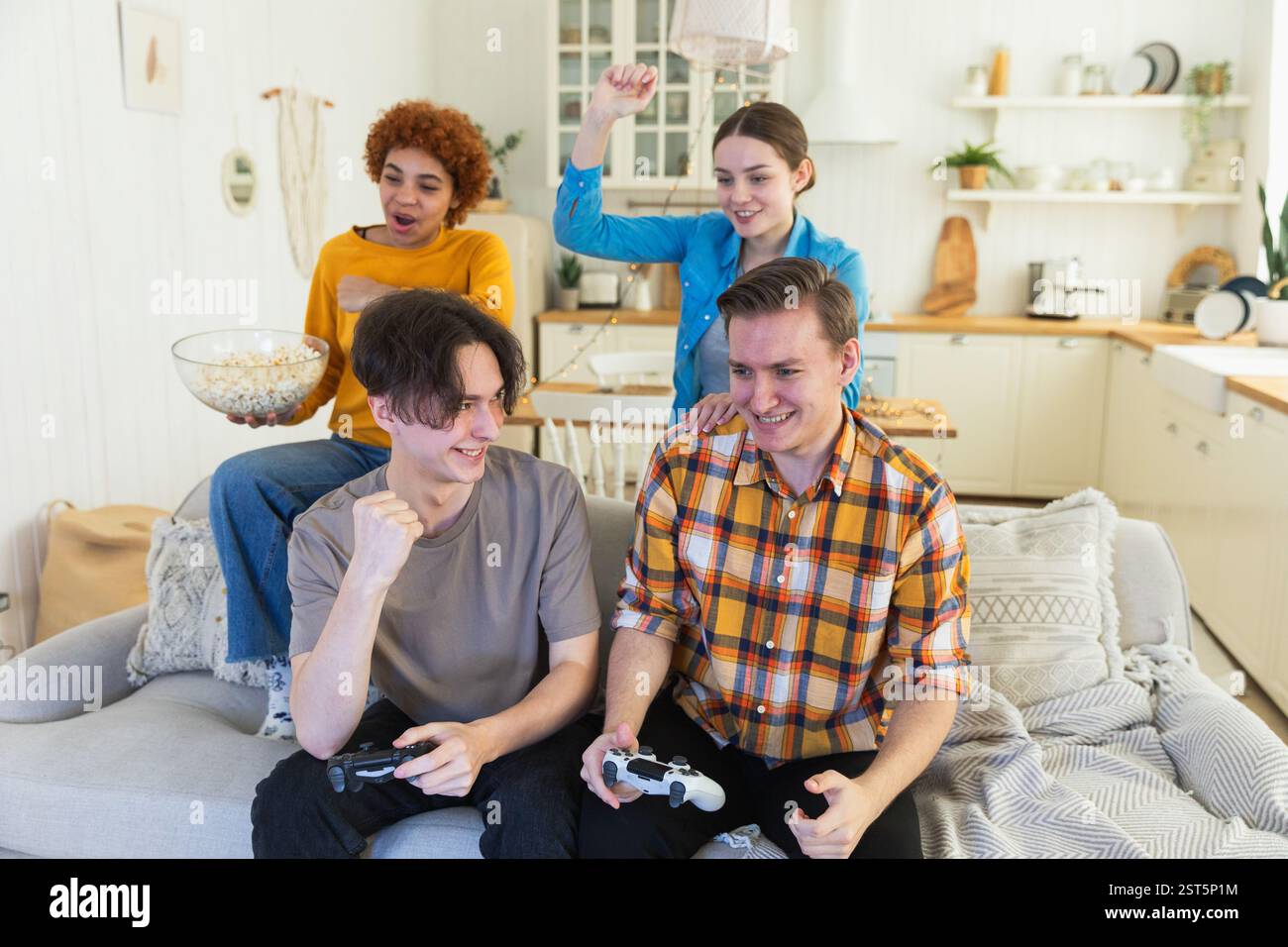 Home party. Cheerful group of friends playing video games at home ...