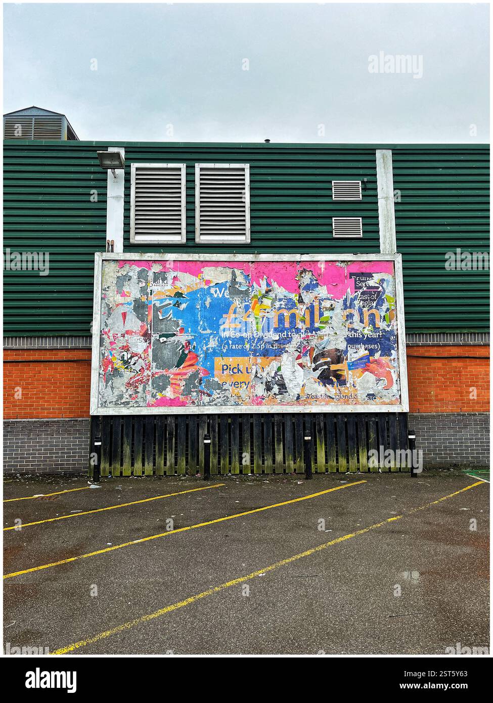 Advertising outdoor billboard on side of warehouse, with shredded ...