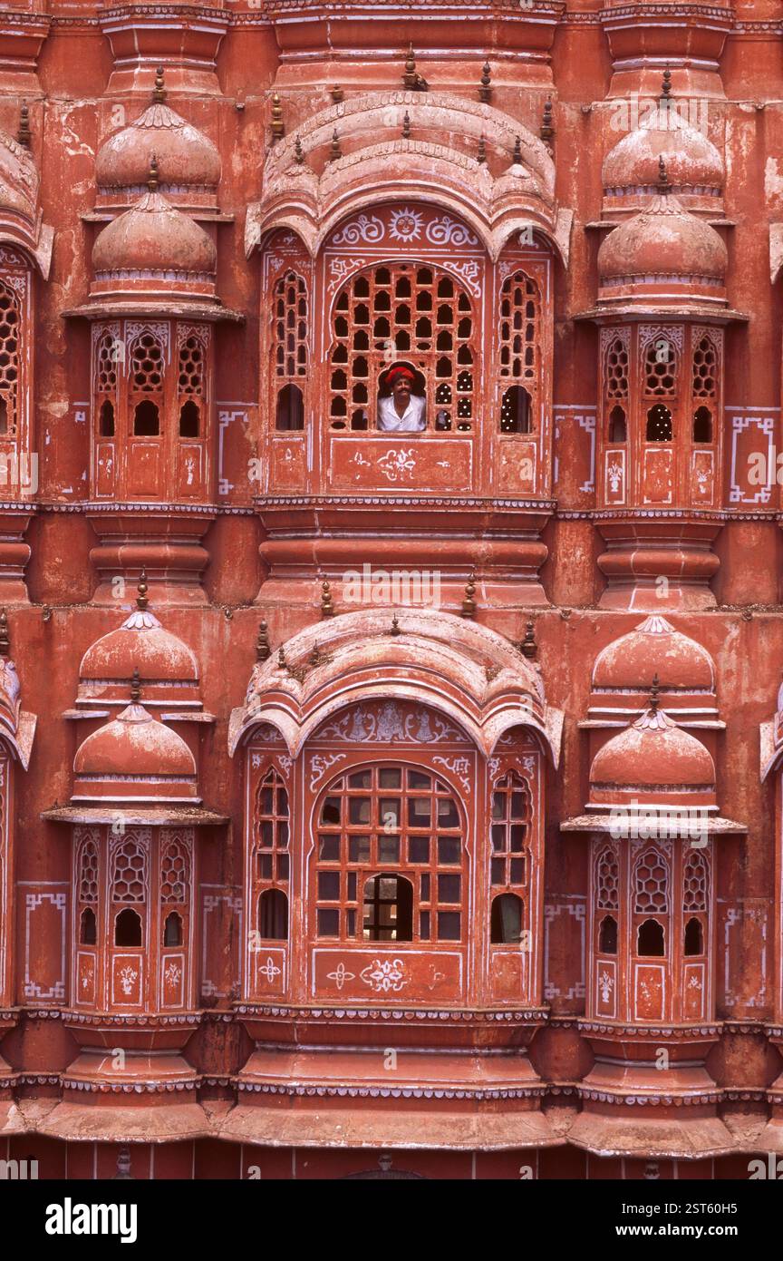 Rajasthani man viewing from window of Hawa Mahal Palace of wind, Jaipur ...