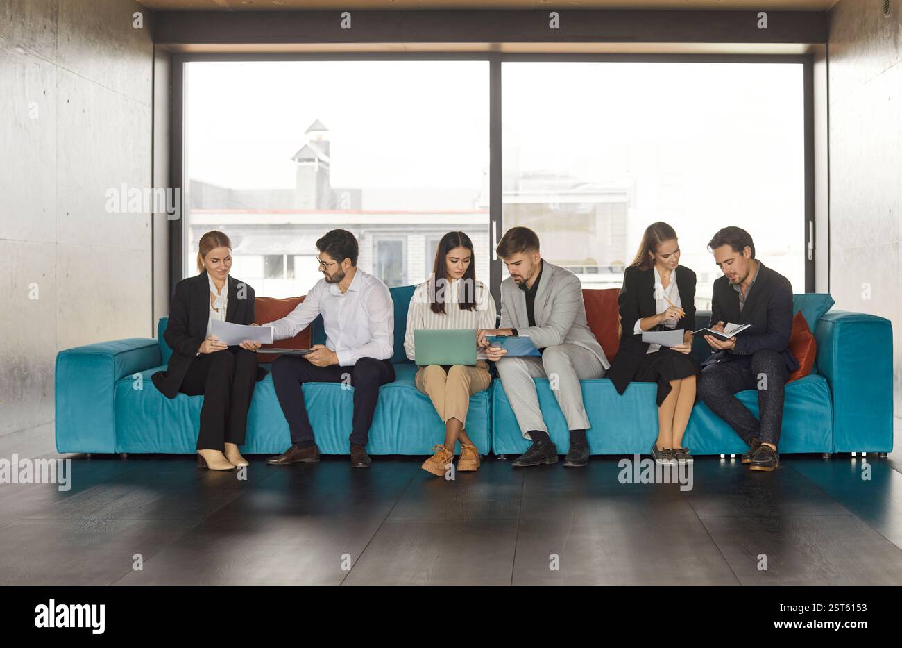 Group of applicants sitting in modern office preparing for first ...