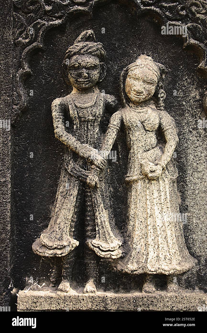 Indian couple, wife holding hand of the husband, carved on the wall of ...