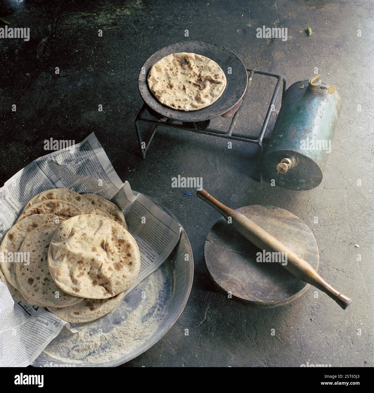 Cooking the Indian bread roti on an portable kerosene stove, the ...