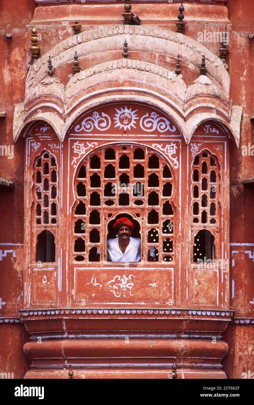 Rajasthani man viewing from window of Hawa Mahal Palace of wind, Jaipur ...