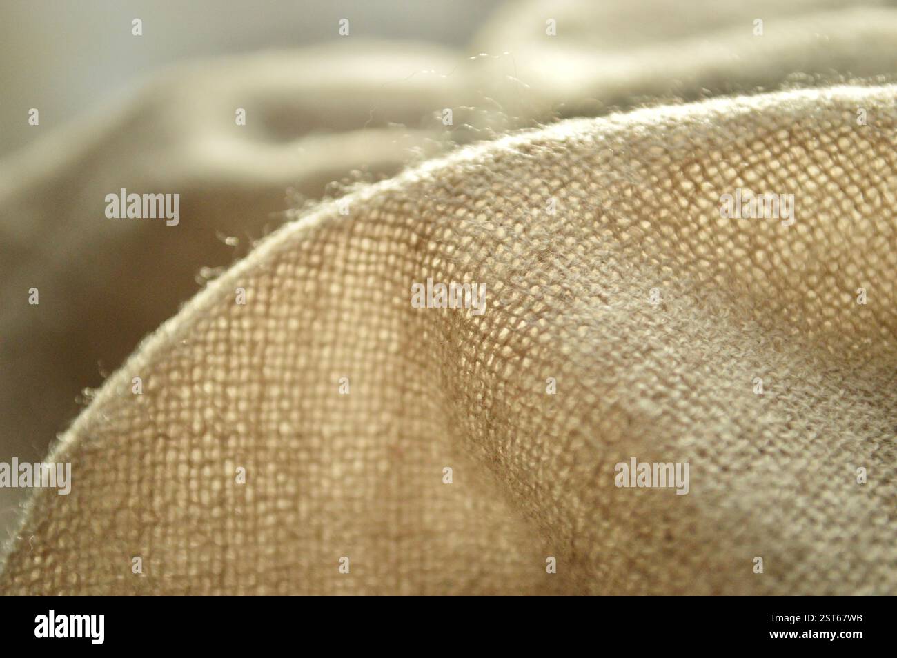 Close-up shot displaying the intricate textures of a coarsely woven burlap fabric with soft ...