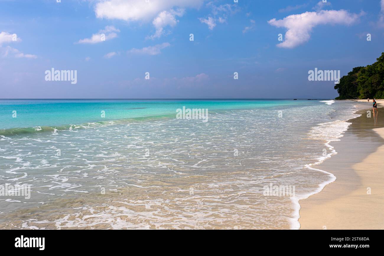one person is distance, walking into ocean, showing he beauty of ...
