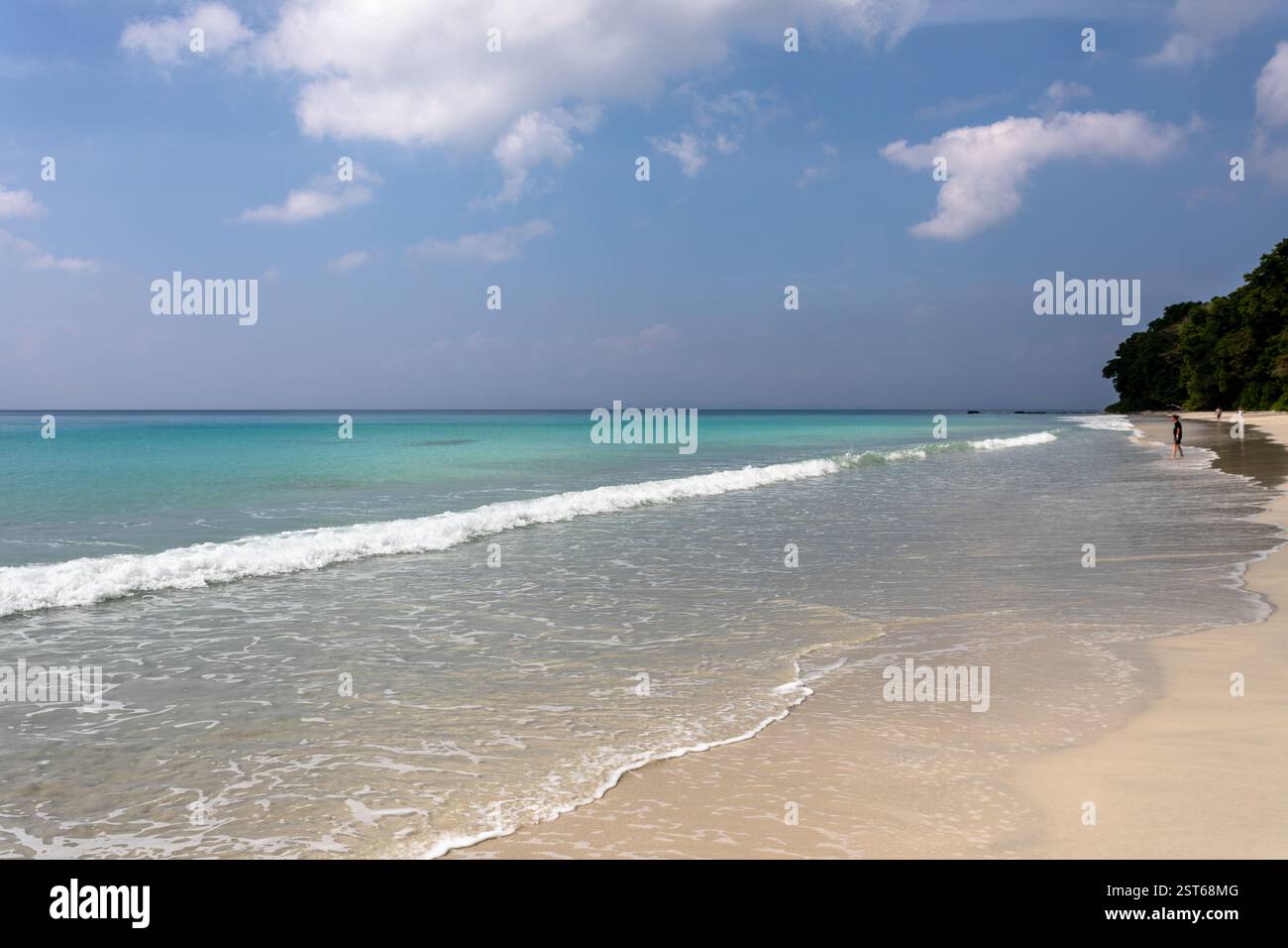 one person is distance, walking into ocean, showing he beauty of ...