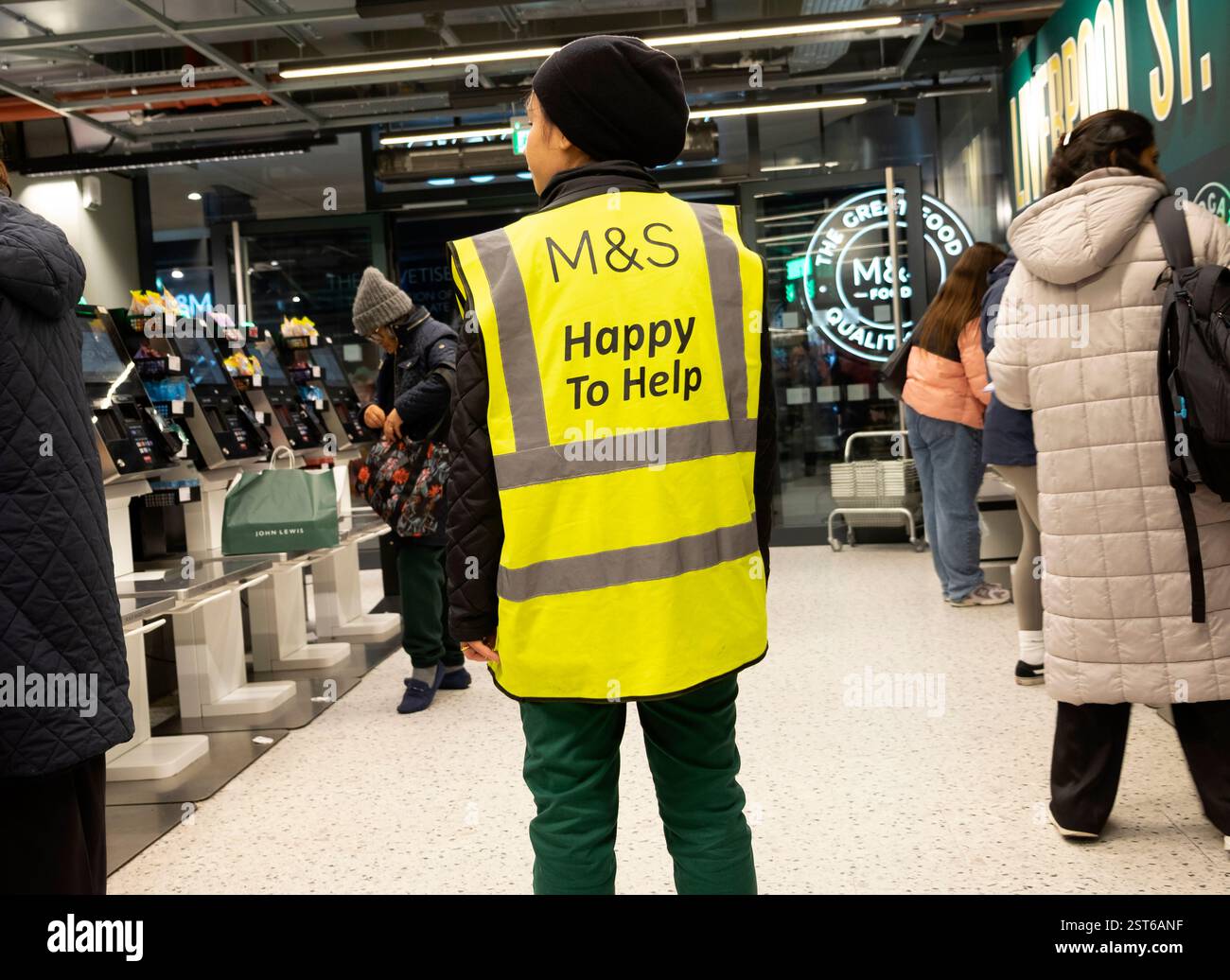 M&S Marks and Spencer worker Happy to Help sign on uniform back helping ...