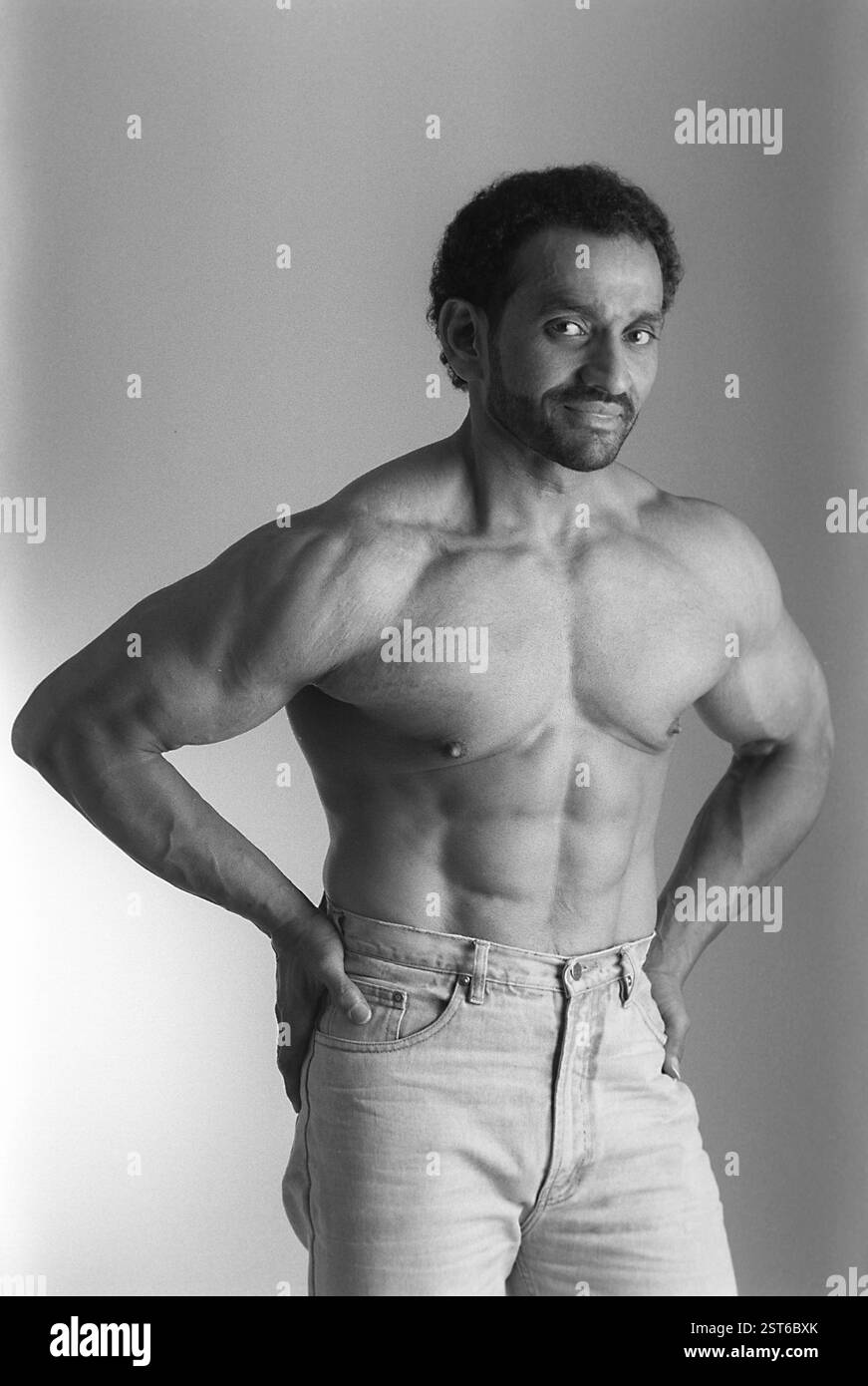 Young Indian Medium shot of male body builder as he flexes his stomach ...
