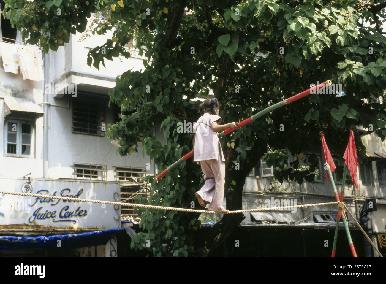 Street performer balancing on rope Stock Photo - Alamy