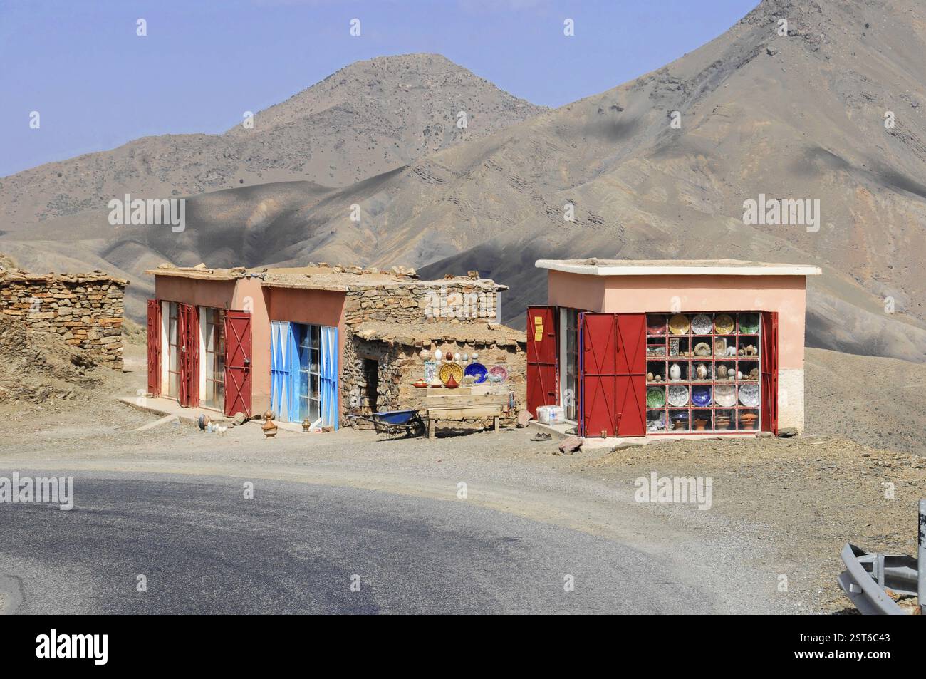 Two small stone huts by the roadside in a mountainous desert landscape ...