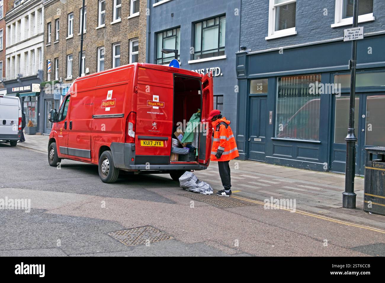 Red Royal Mail van and postal worker employee man unloading delivery ...
