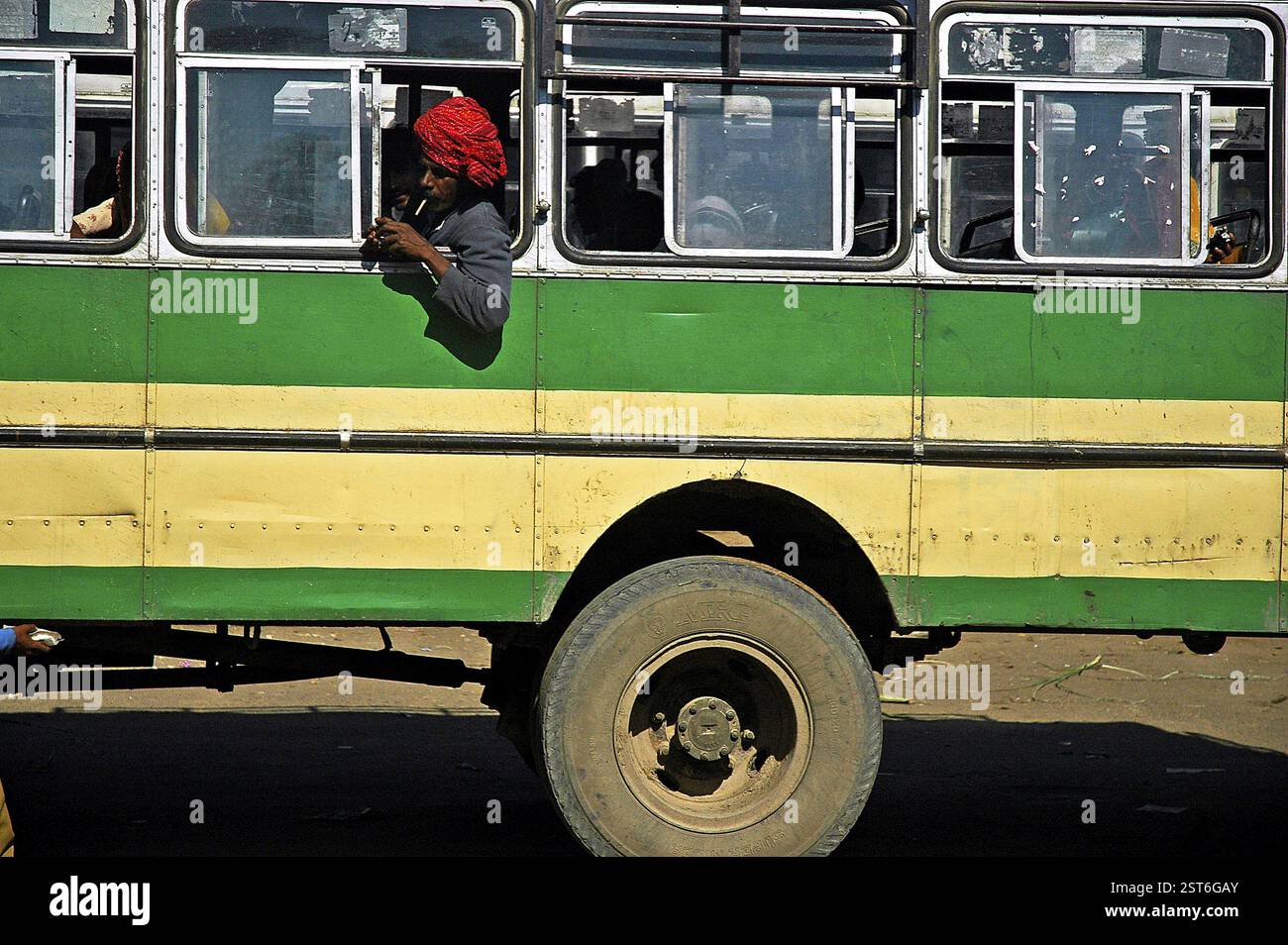 Bus, man red turban smoking cigarette bedi in yellow green bus, India ...