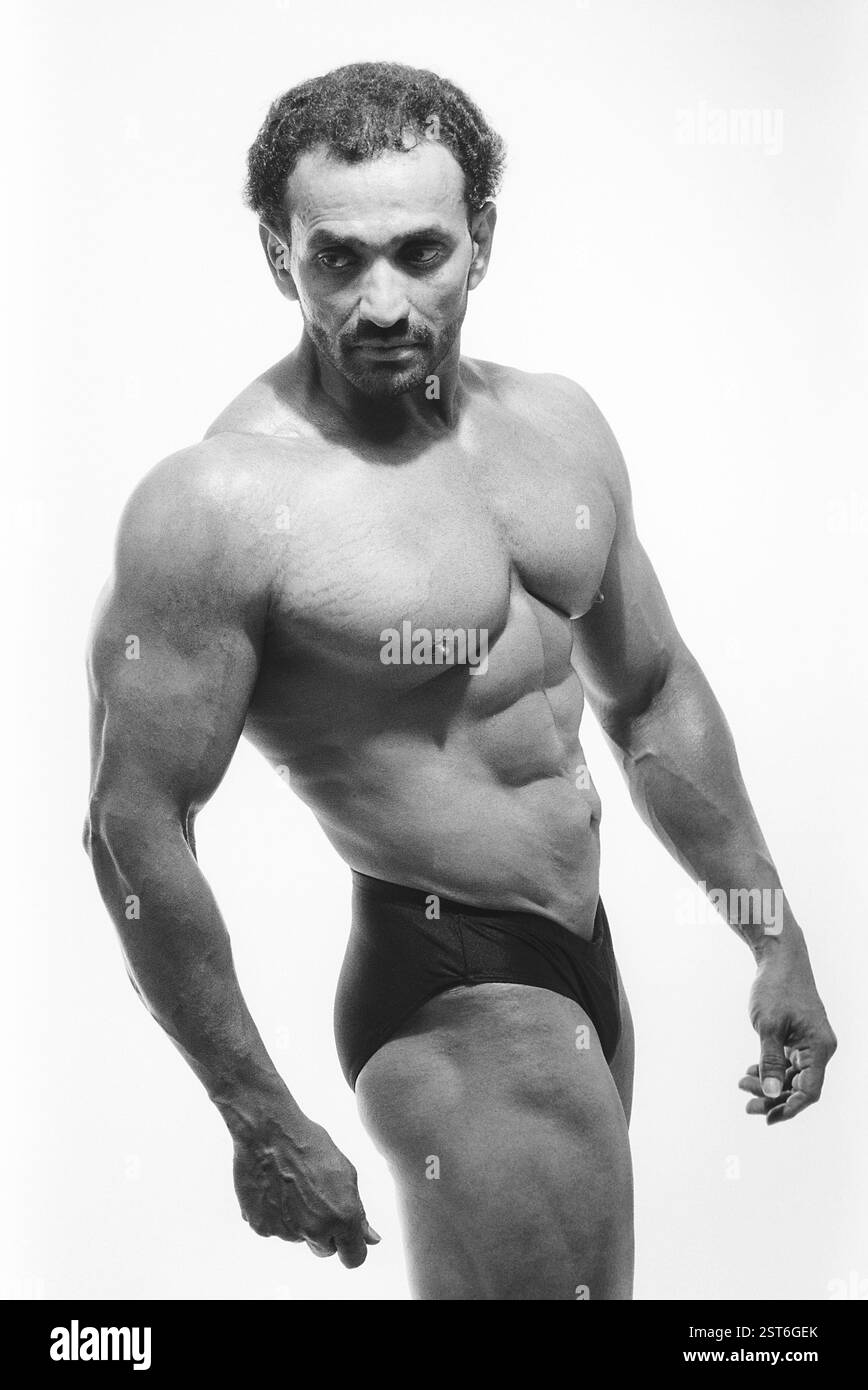 Young Indian Medium shot of a male bodybuilder as he flexes his stomach muscles Stock Photo - Alamy