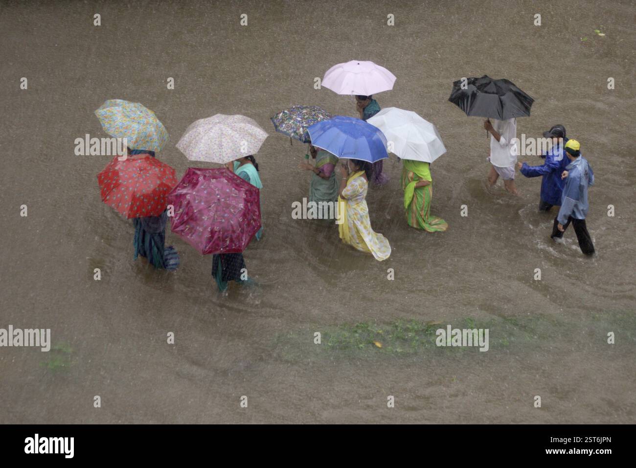 Showing People are walking with color umbrella in flooded water ...