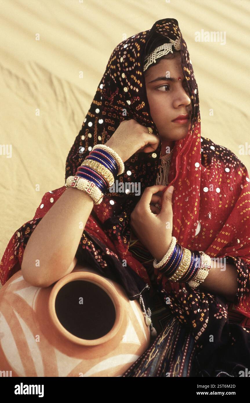 Rajasthani lady in traditional wearing sitting on sand dunes, Udramsar ...