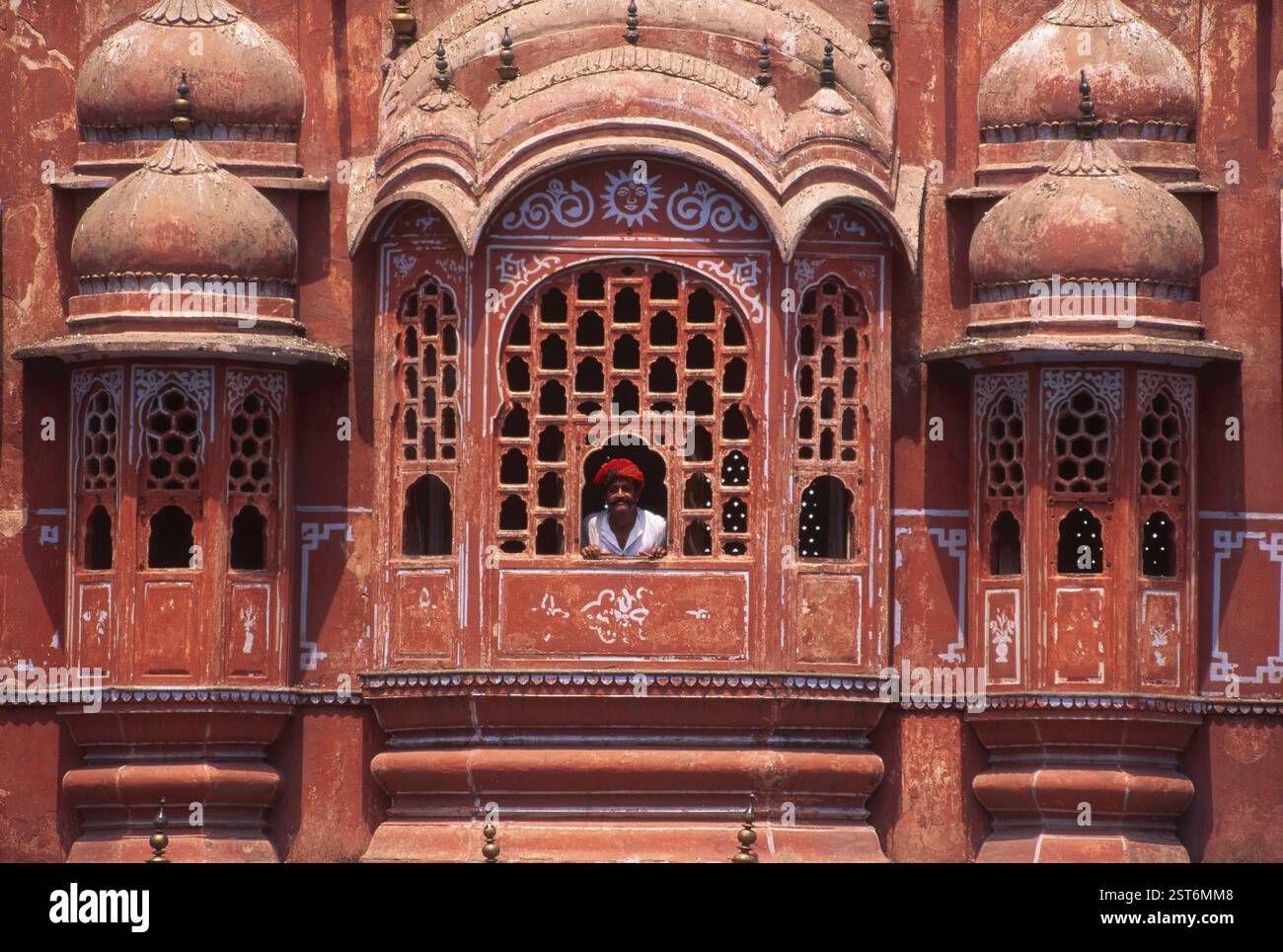 Rajasthani man viewing from window of Hawa Mahal Palace of wind, Jaipur ...
