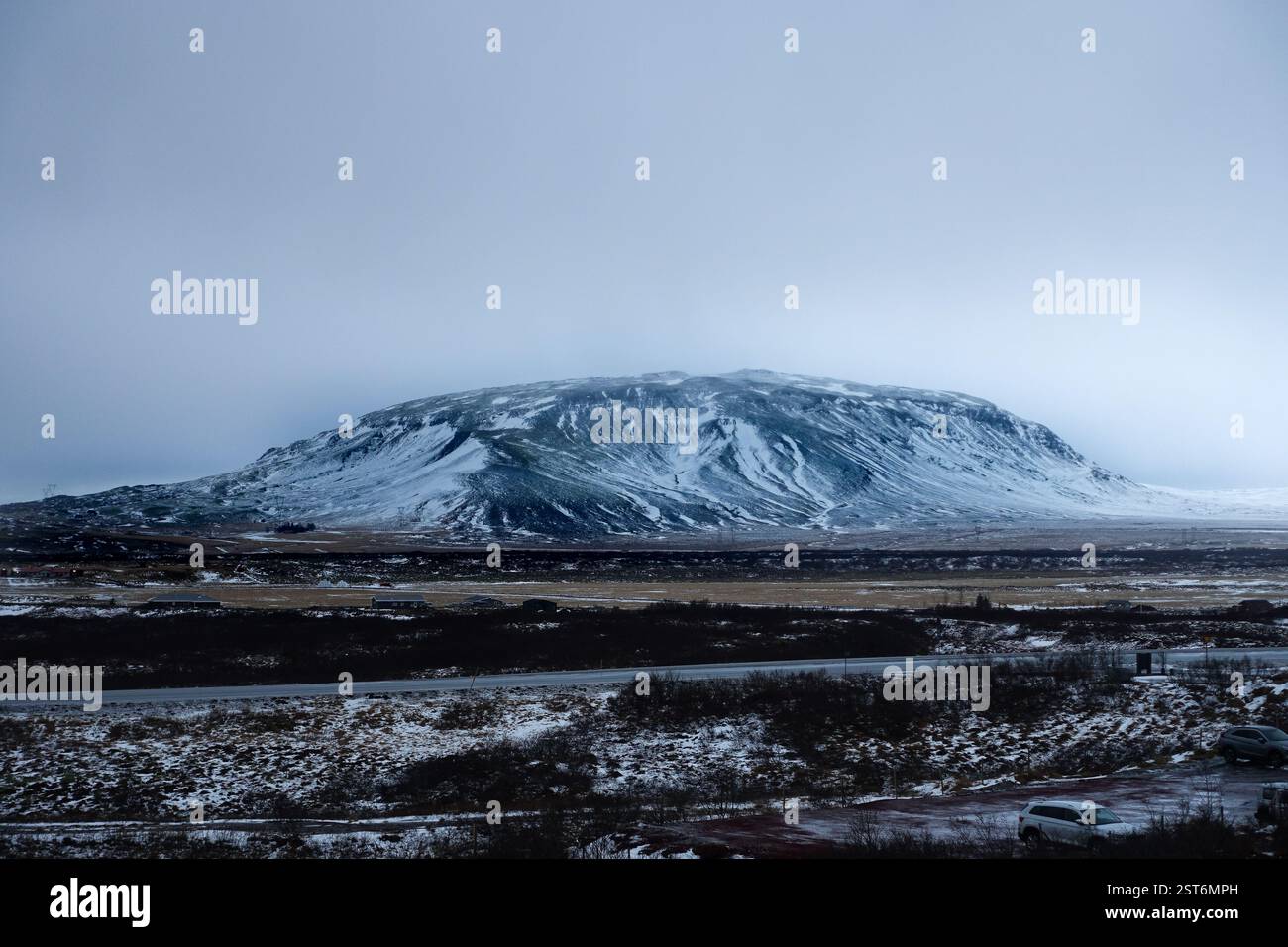 A snow-covered mountain under an overcast sky, showcasing the raw ...