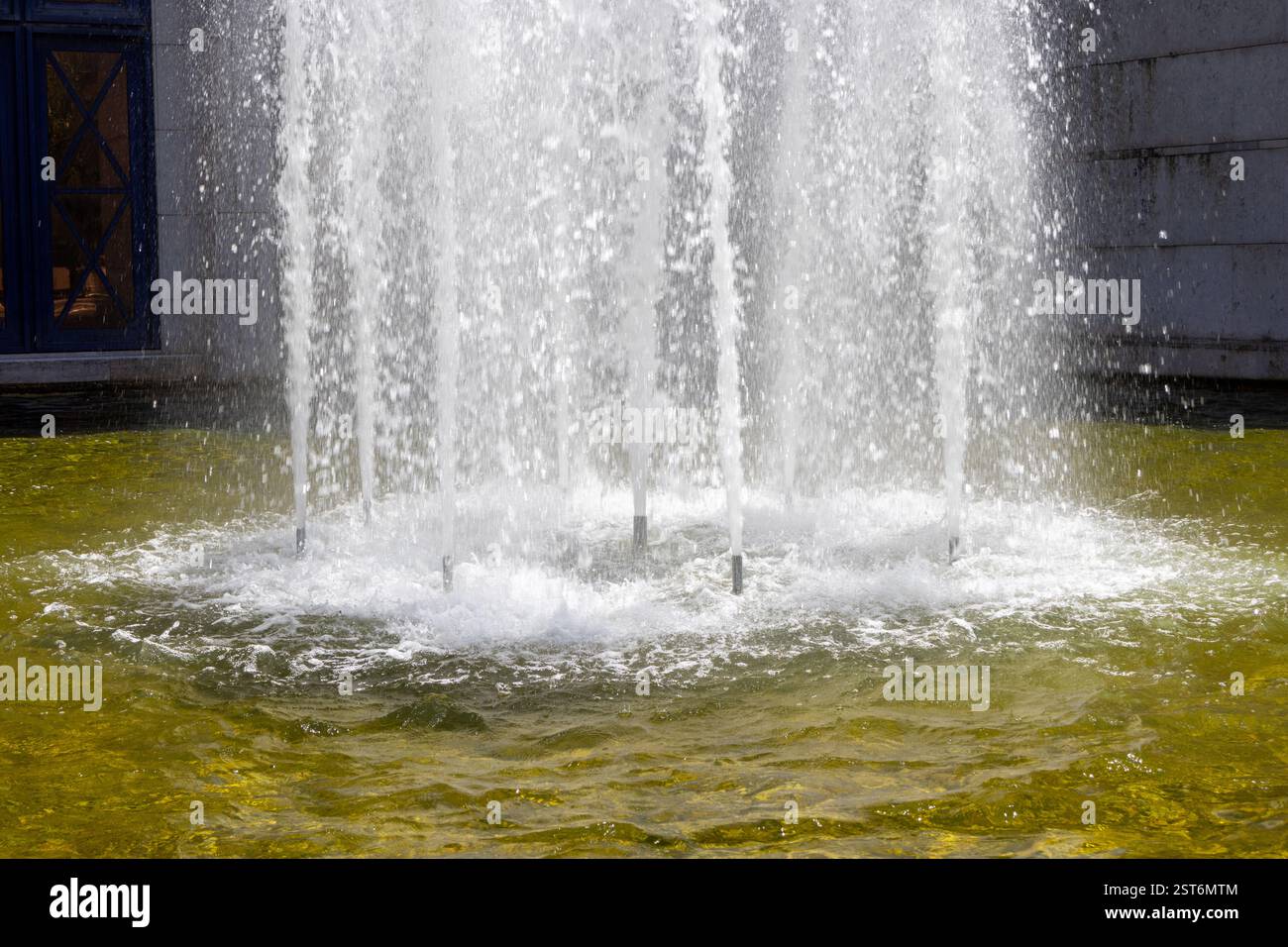 Jets of water spraying into fountain basin, creating refreshing ...