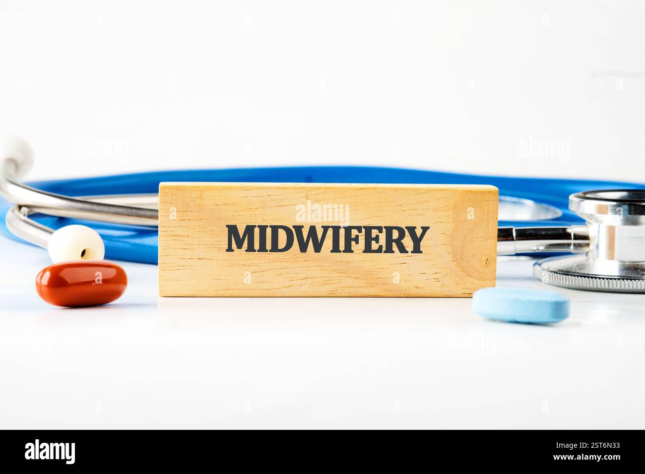 A wooden block marked 'midwifery' sits with medical tools, showcasing ...
