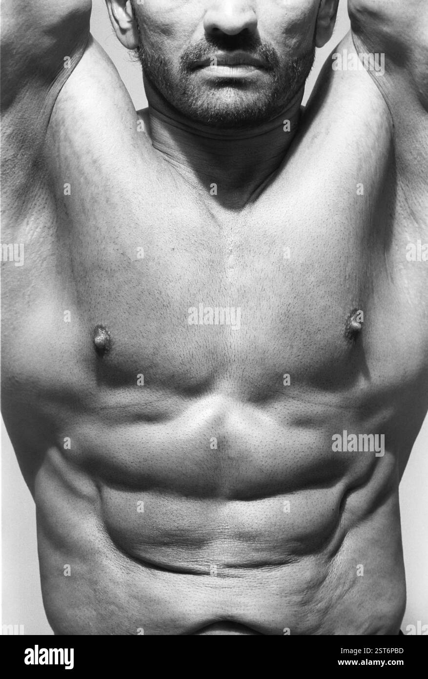 Young Indian Medium shot of male body builder as he flexes his stomach ...
