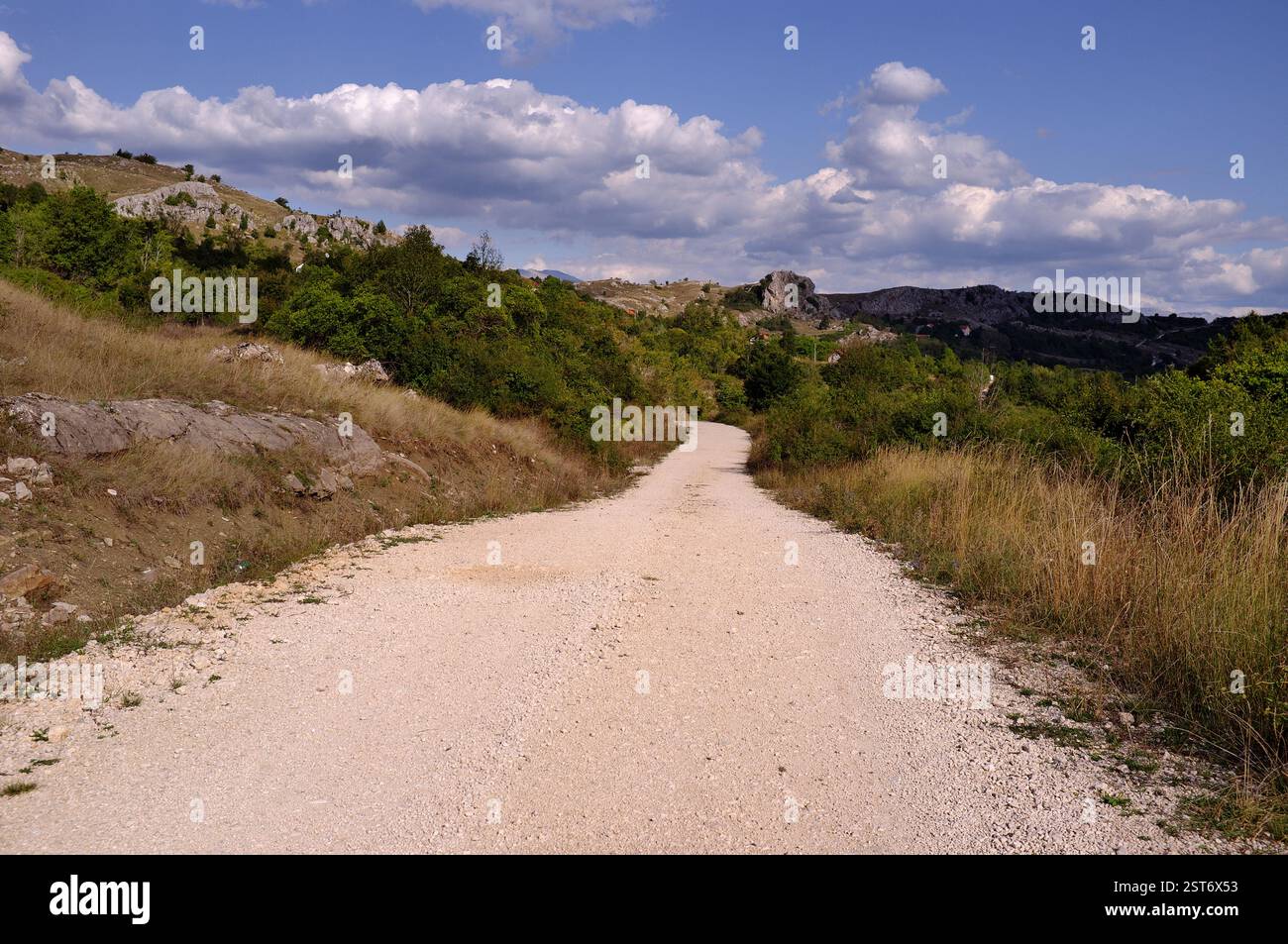 rural gravel road to Kljuc and beautiful cloudy sky, Gacko, Bosnia and ...