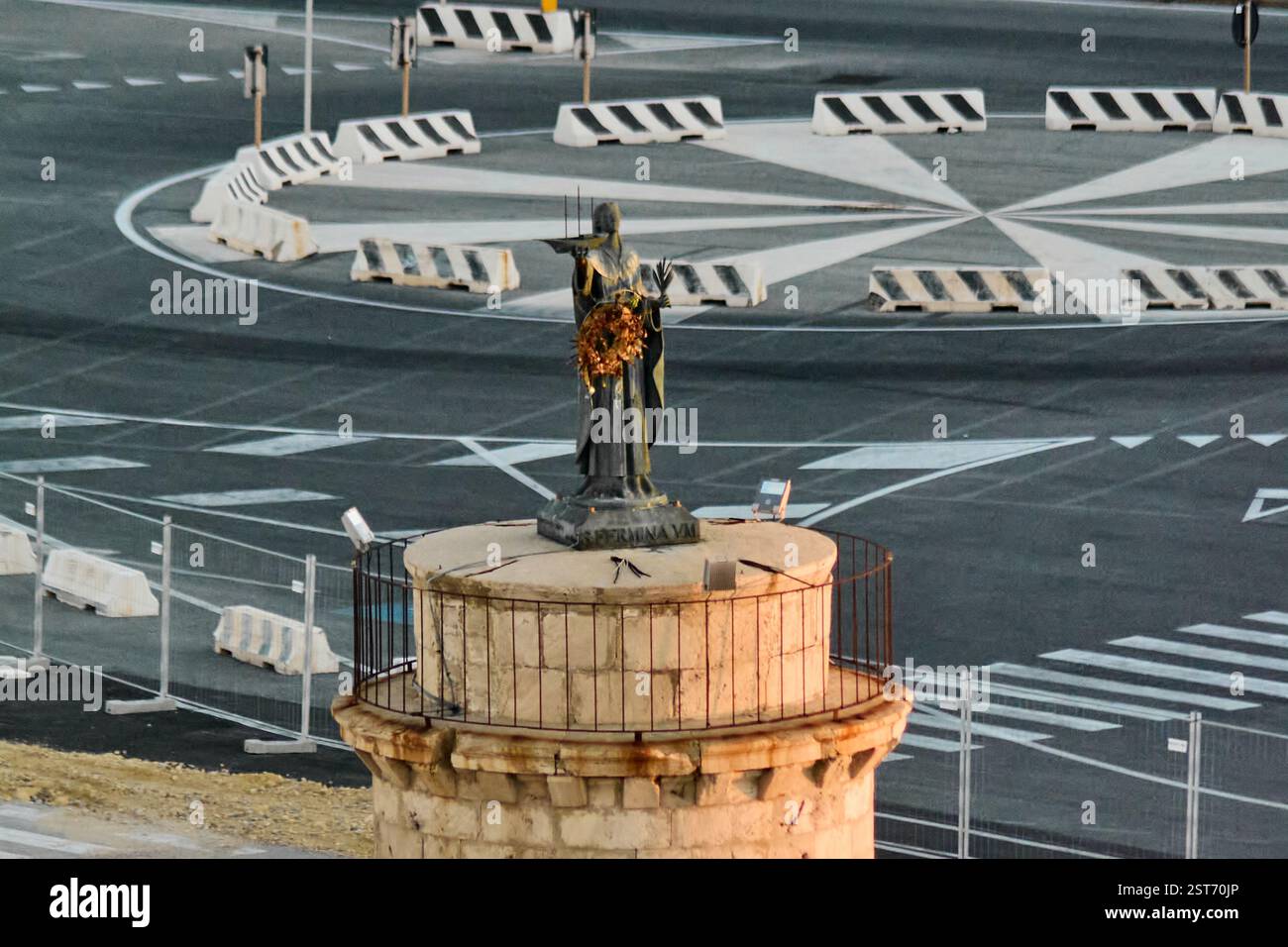 Historic stone tower with a bronze statue on top, located in the port ...