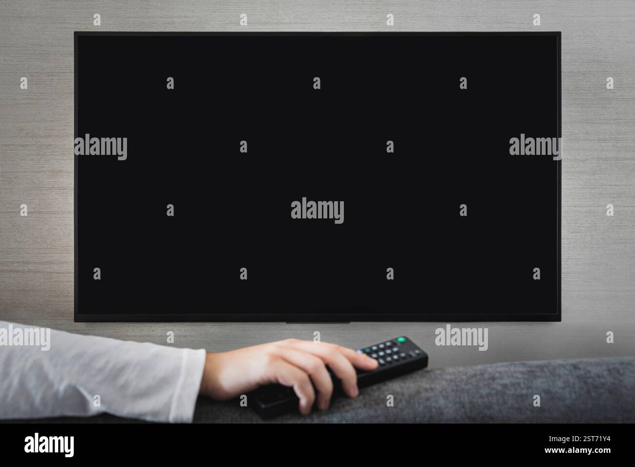 Television remote control changes channels thumb on the black TV screen ...