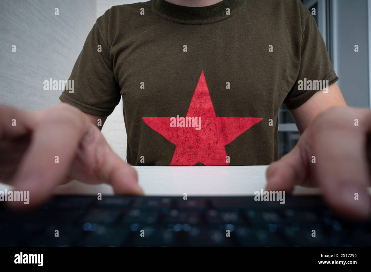 a male soldier in a military uniform is sitting at a computer. center ...