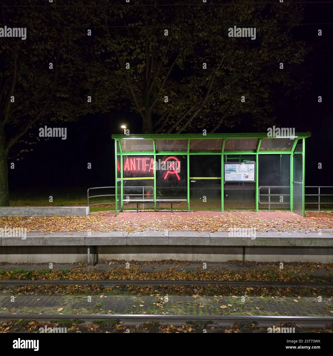 A nighttime bus stop scene featuring vibrant political graffiti that ...