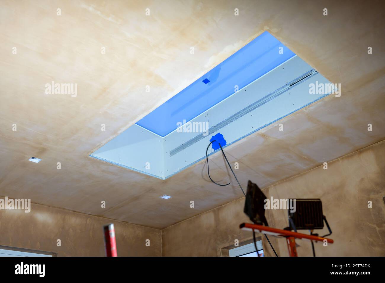 A construction site with ceiling drywall installation underway, showing ...
