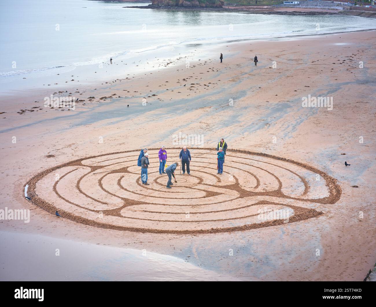Building a maze on the beach of Torre Abbey Sands, Devon, England, with ...