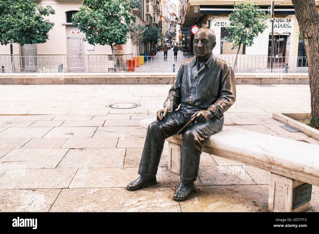 Life-size bronze statue of Pablo Picasso on a marble bench in Plaza de ...