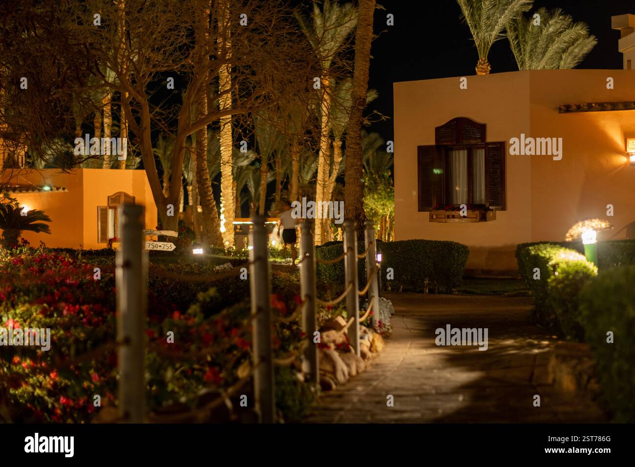 Serene evening stroll through a beautifully lit resort pathway in Egypt ...