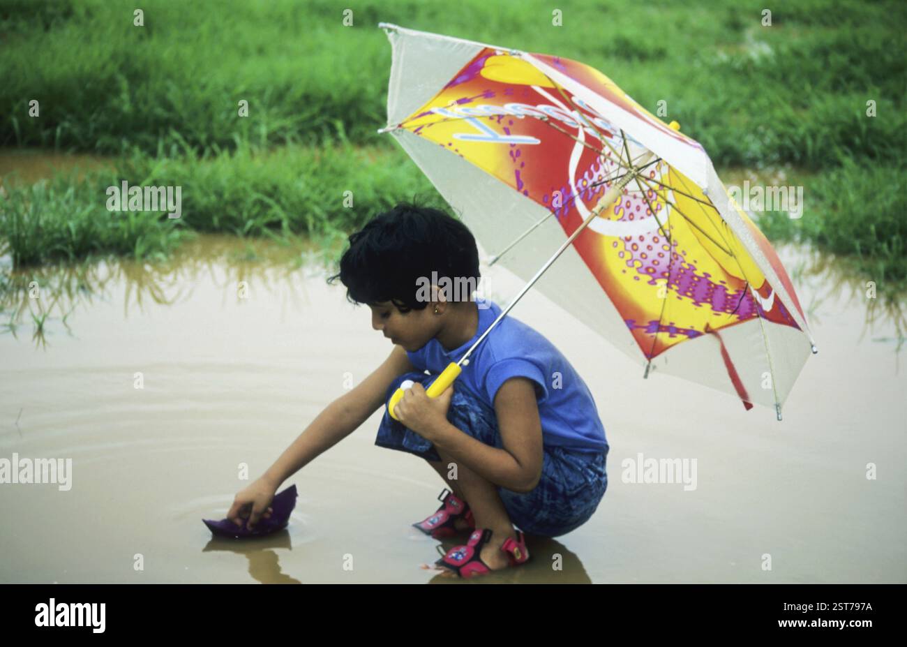 Girl sailing paper boat in rain water, dadar, bombay mumbai ...