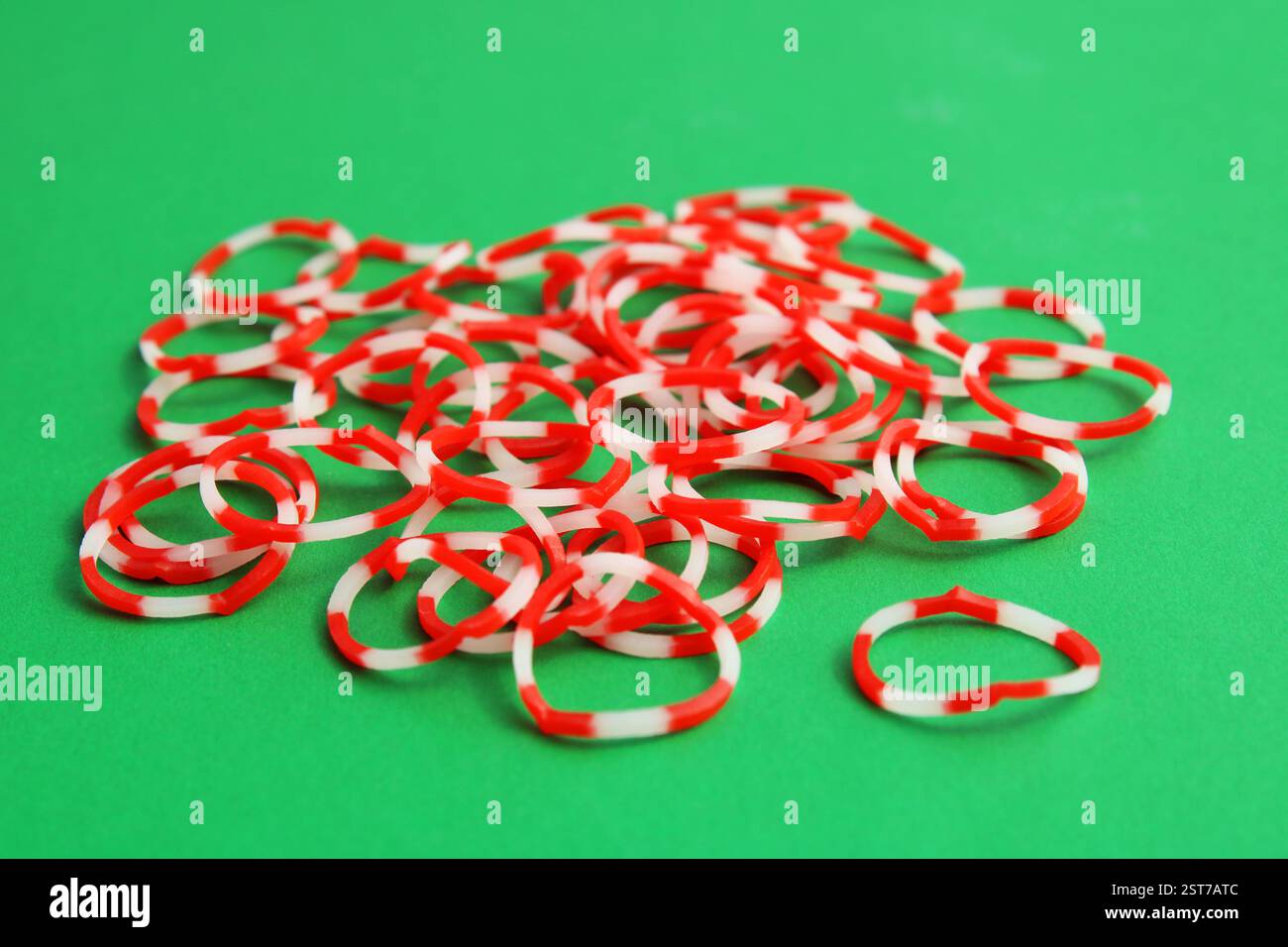 Many elastic bands with red and white combination on green background ...