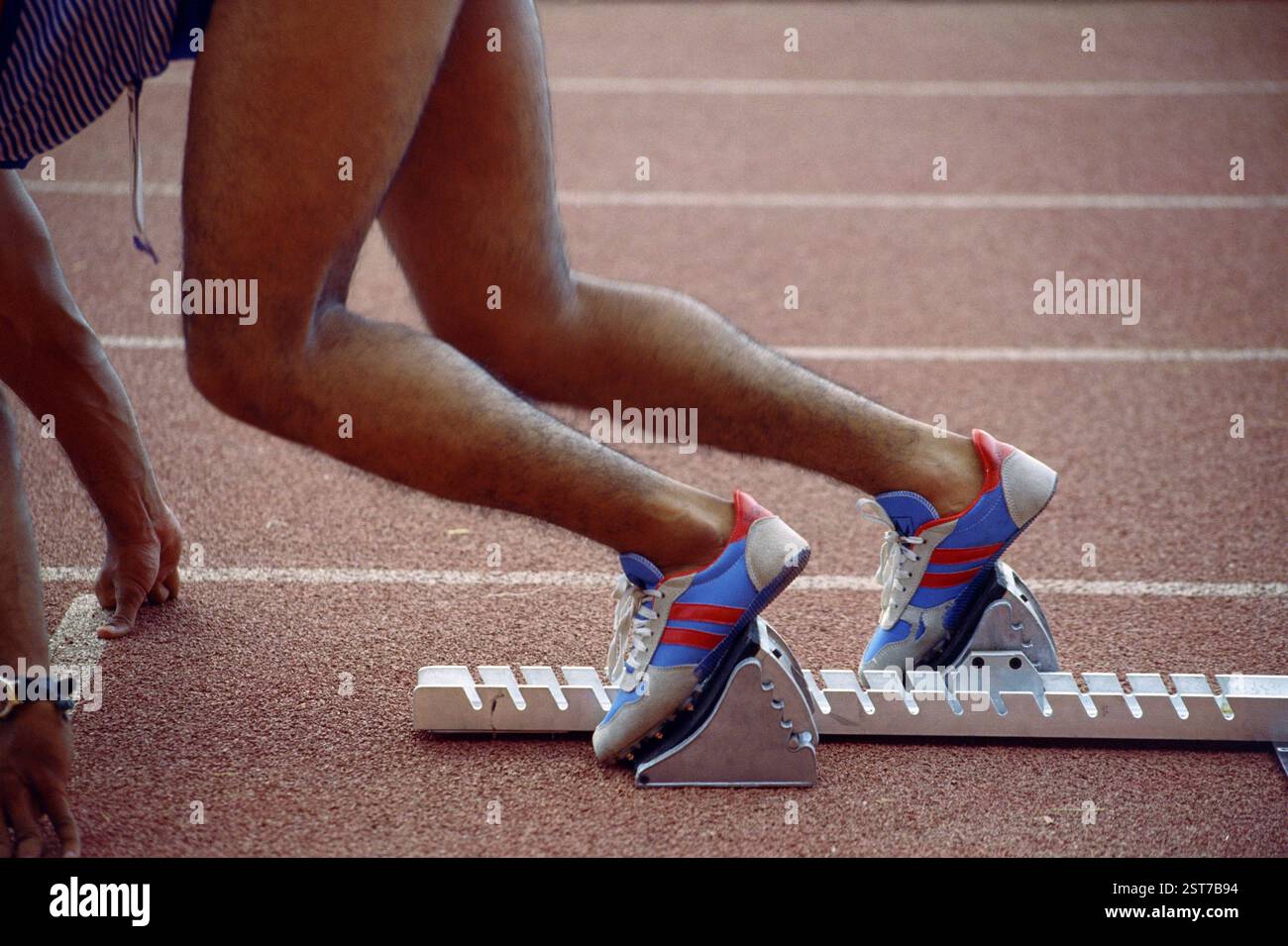 Runner feet on starting block on racetrack MR Stock Photo - Alamy