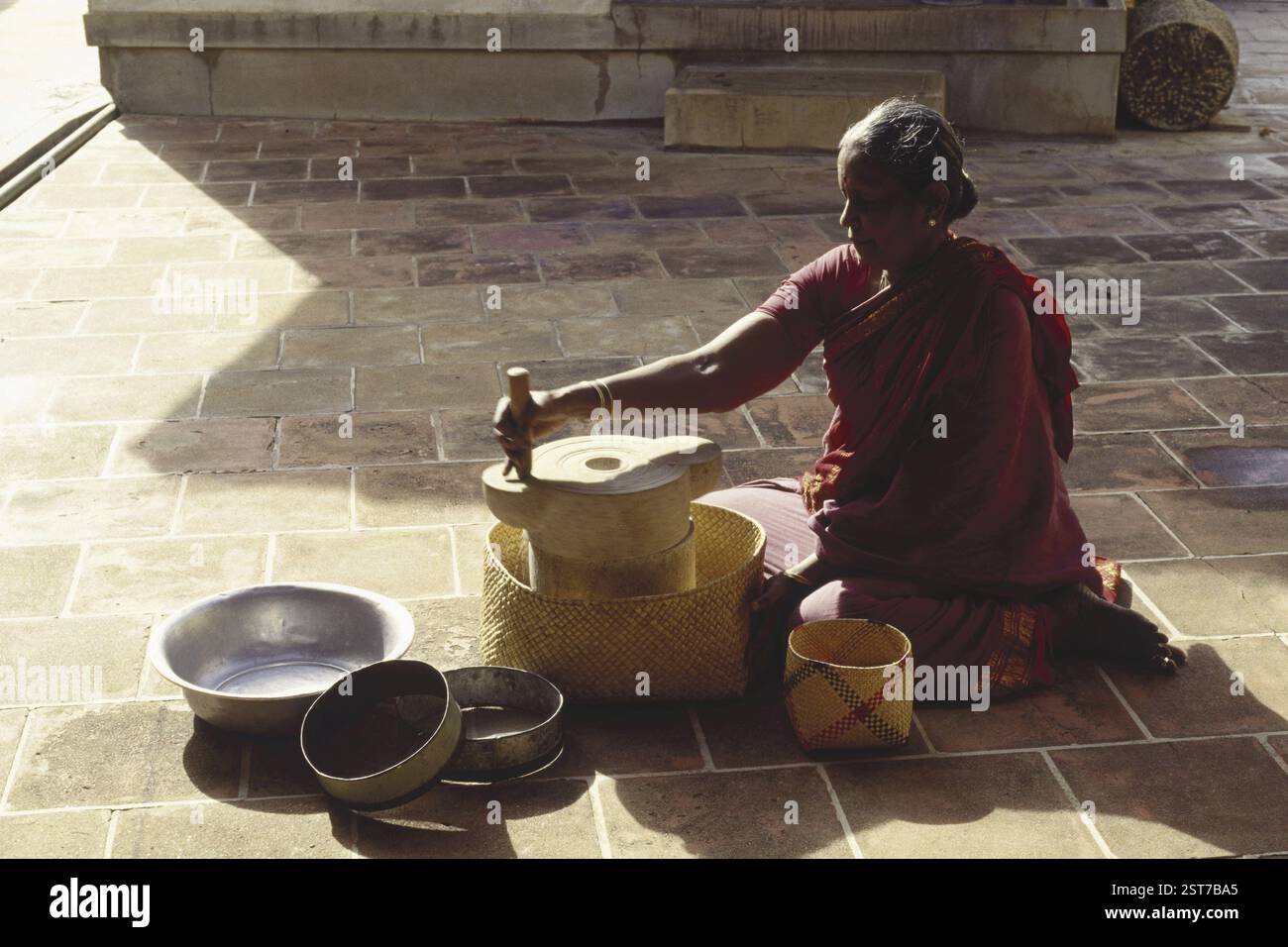 Rice ground lady using traditional pair of grinding stones, top roasted ...
