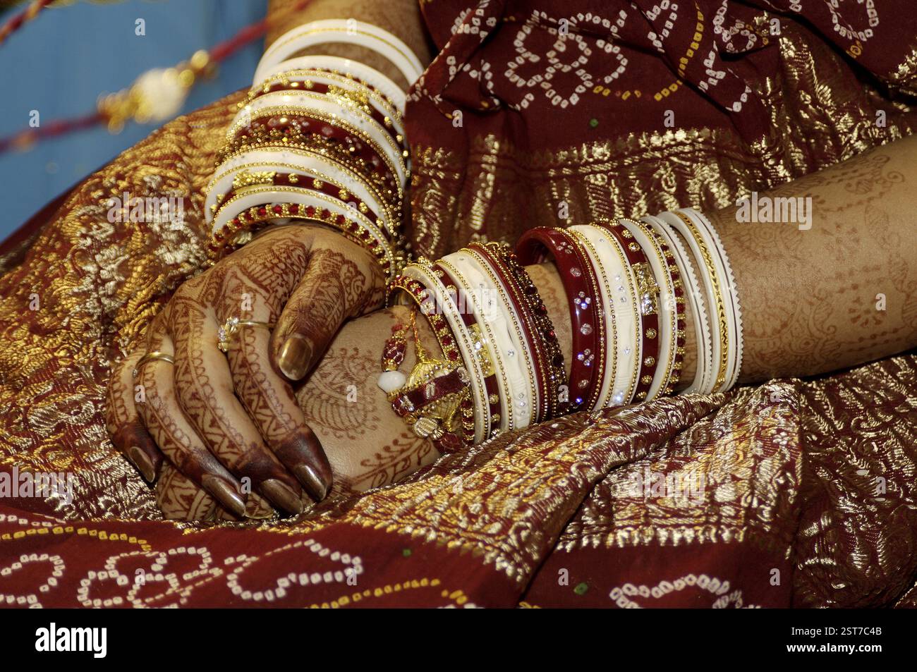 South Asian Indian Bride wearing golden bangles and showing mehandi in ...