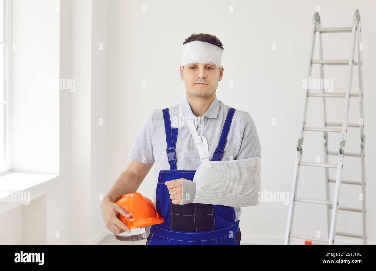 Injured man after accident standing on construction site with arm in ...