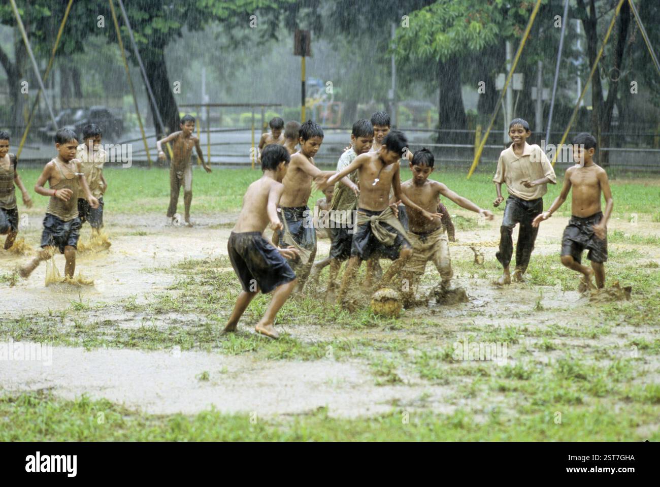 Boys playing football in mud Stock Photo - Alamy