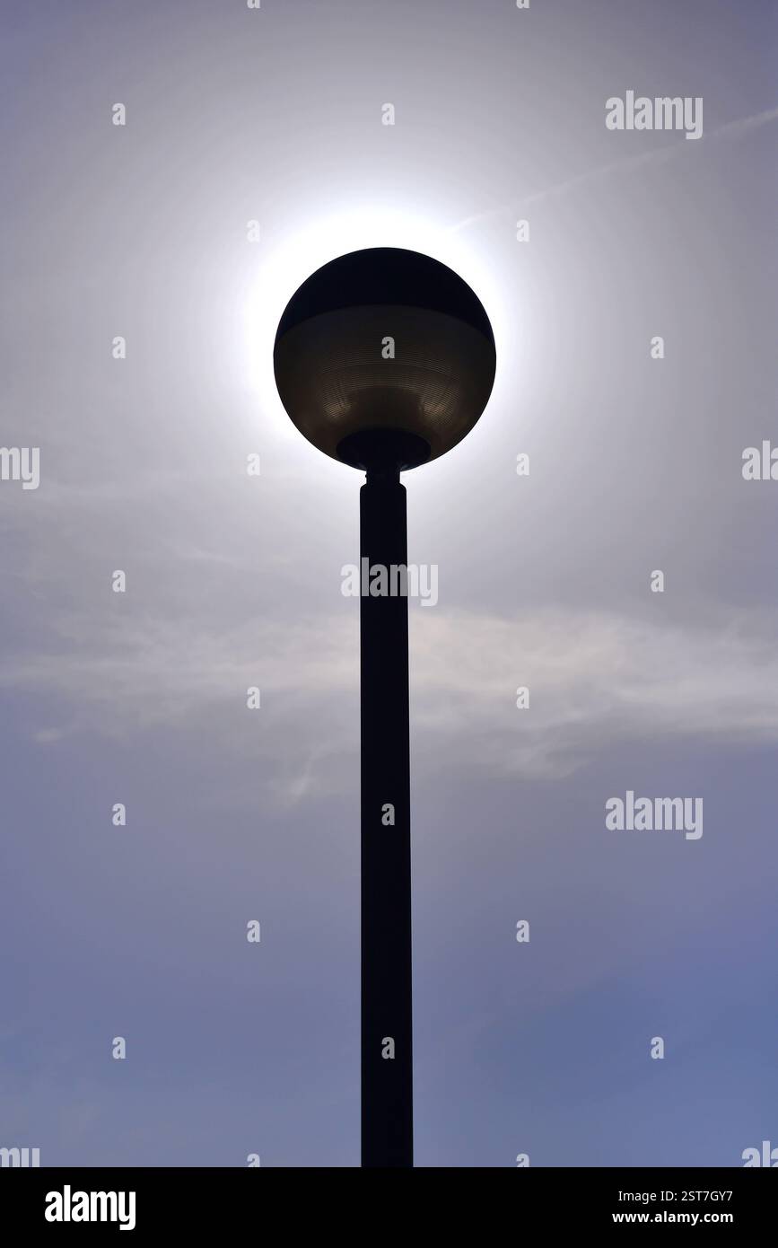Sunlight hidden behind street lamp of street lighting Stock Photo - Alamy