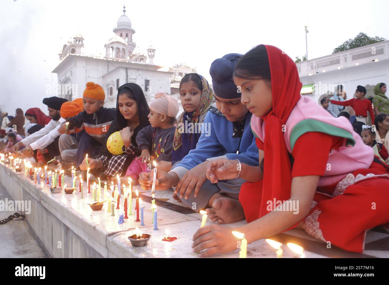 Children lighting candles on the pomegranates of the Golden Temple ...
